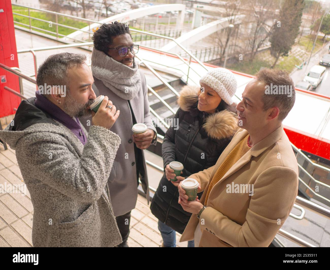 Four office workers taking a coffee break in a lively business district ...