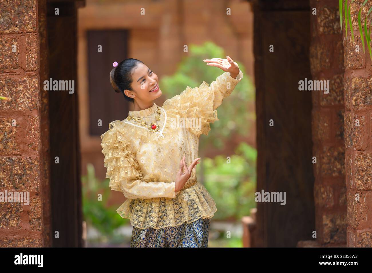 Young beautiful woman dressed in beautiful Thai costumes, pose hands in ...