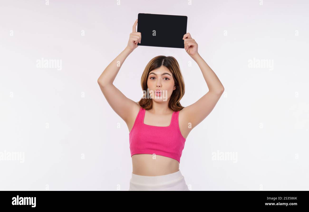 Portrait of excited young woman holding tablet mock up isolated over white background ...