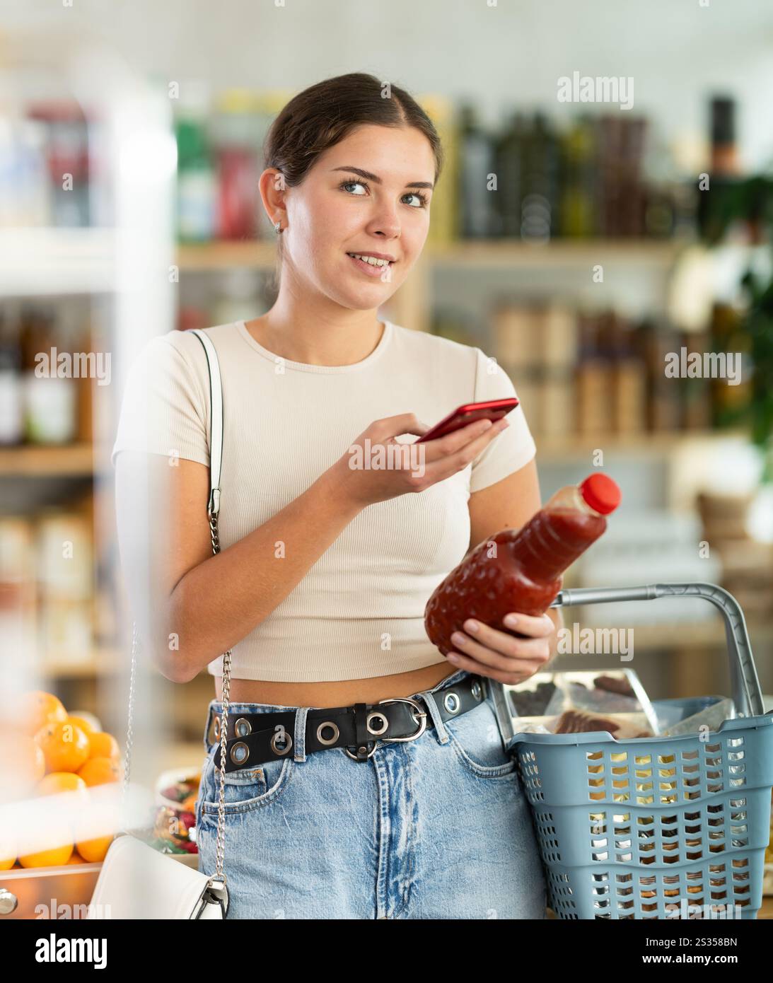 Young woman scanning qr code of tomato juice Stock Photo - Alamy