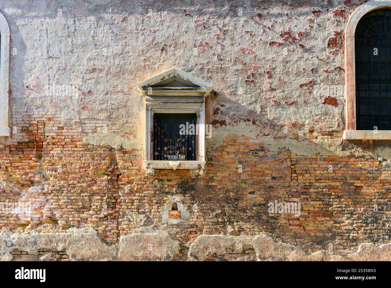 White window on old house wall Cracks in concrete visible red bricks in ...