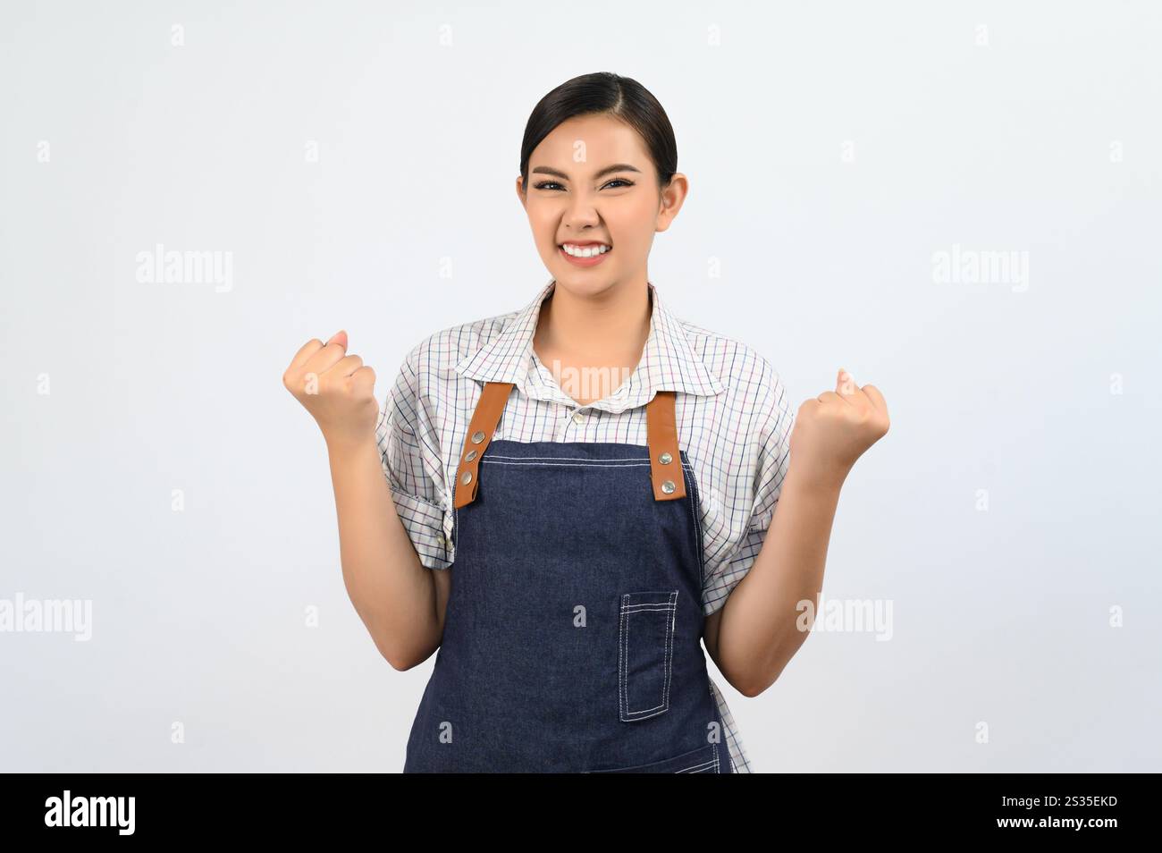 Portrait Asian young woman in waitress uniform and apron standing ...