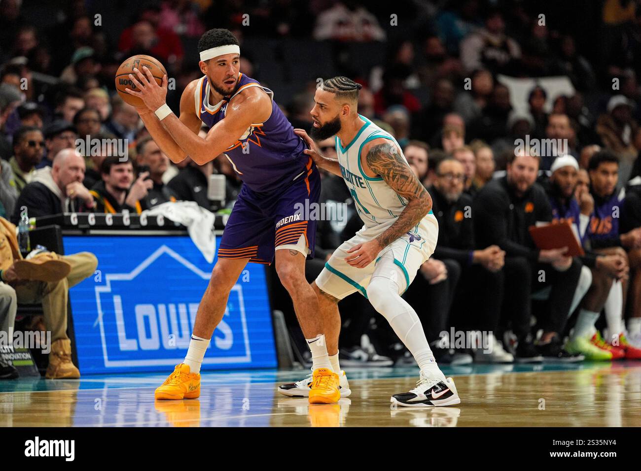 Phoenix Suns guard Devin Booker (1) guarded by Charlotte Hornets ...