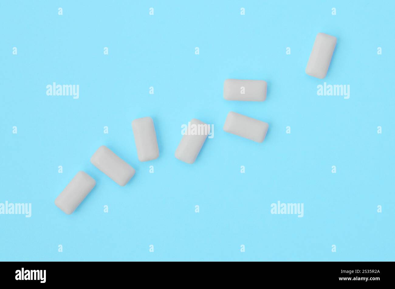 A few chewing gums lie on texture background of fashion pastel blue ...