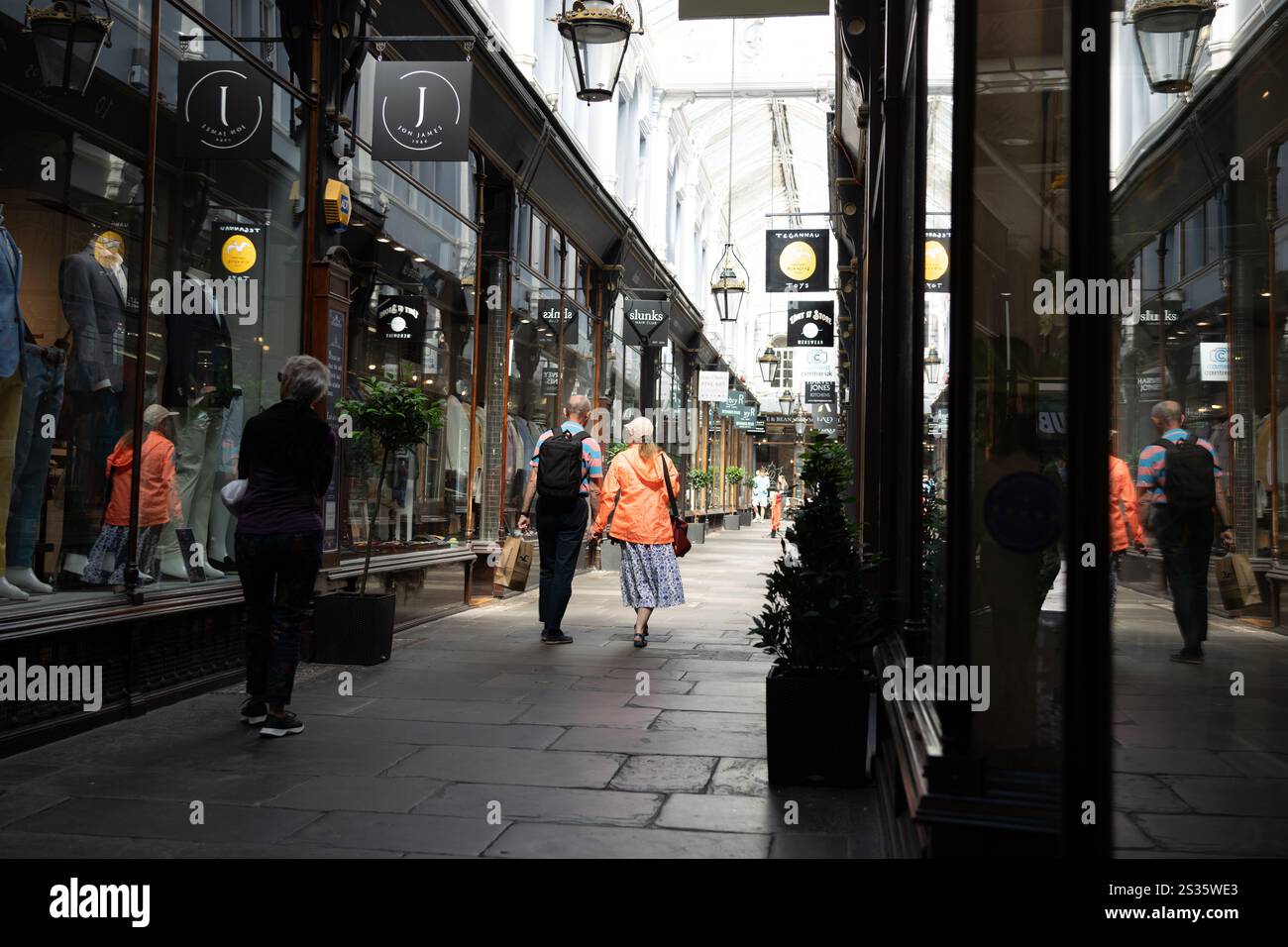 City footpath with woman’s legs and feet leaving frame with patterned ...
