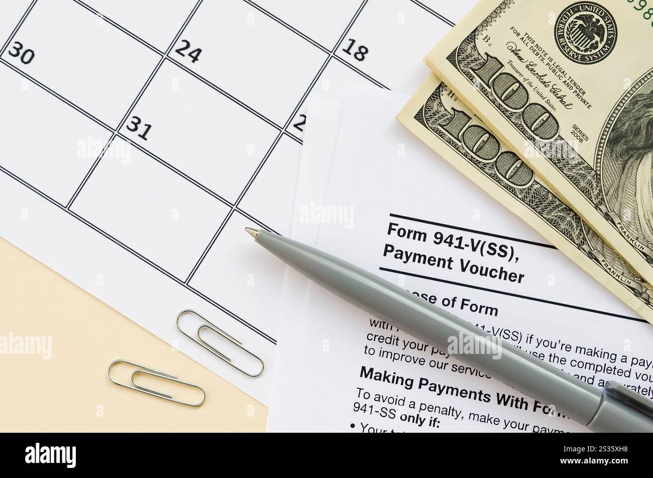 IRS Form 941-V Payment Voucher blank lies with pen and many hundred ...