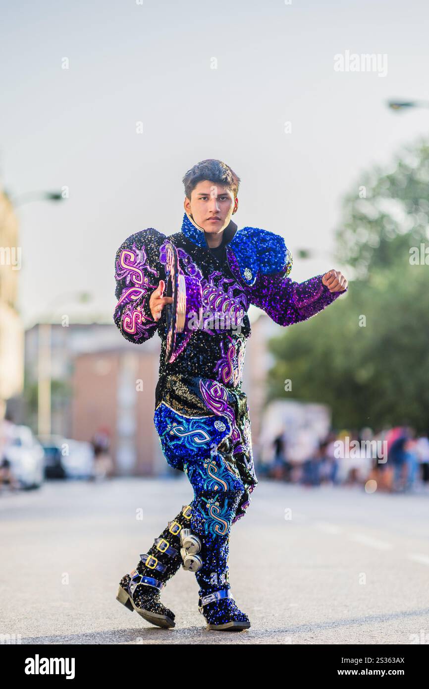 Young dancer in vibrant traditional costume playing tambourine during a ...