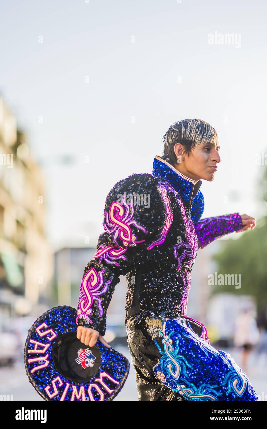 Dancer wearing a sparkling costume holds their hat while performing ...