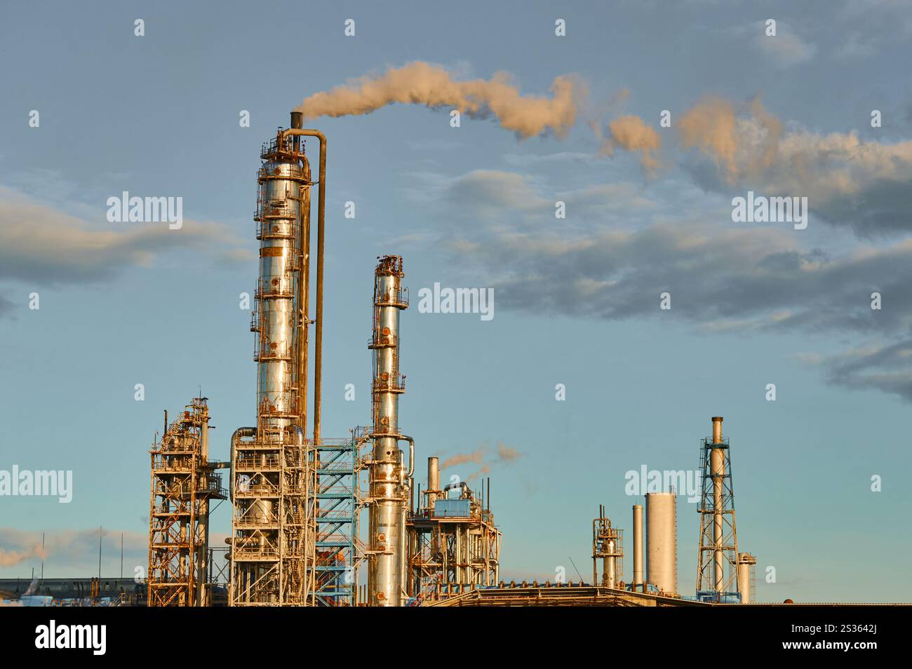 Distillation column at a chemical plant emitting vapor under a clear ...