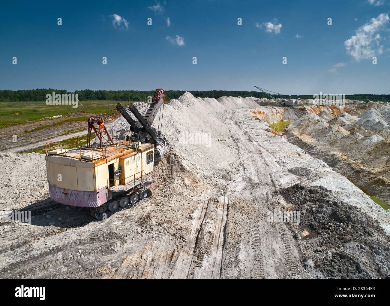 Caterpillar Shovel mining excavator near piles line in chalkquarry ...