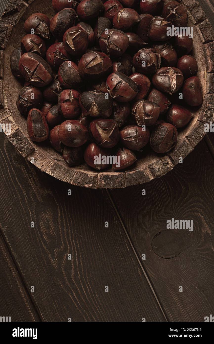 Roasted chestnuts, in a wooden plate, top view, homemade, no people ...