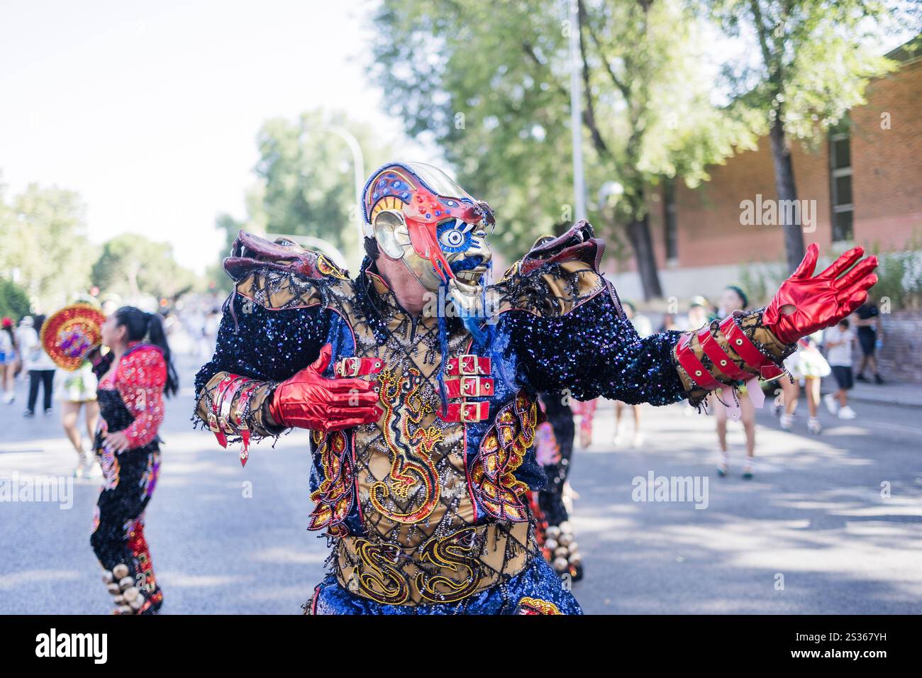 Man wearing colorful traditional clothes and mask dancing during a ...