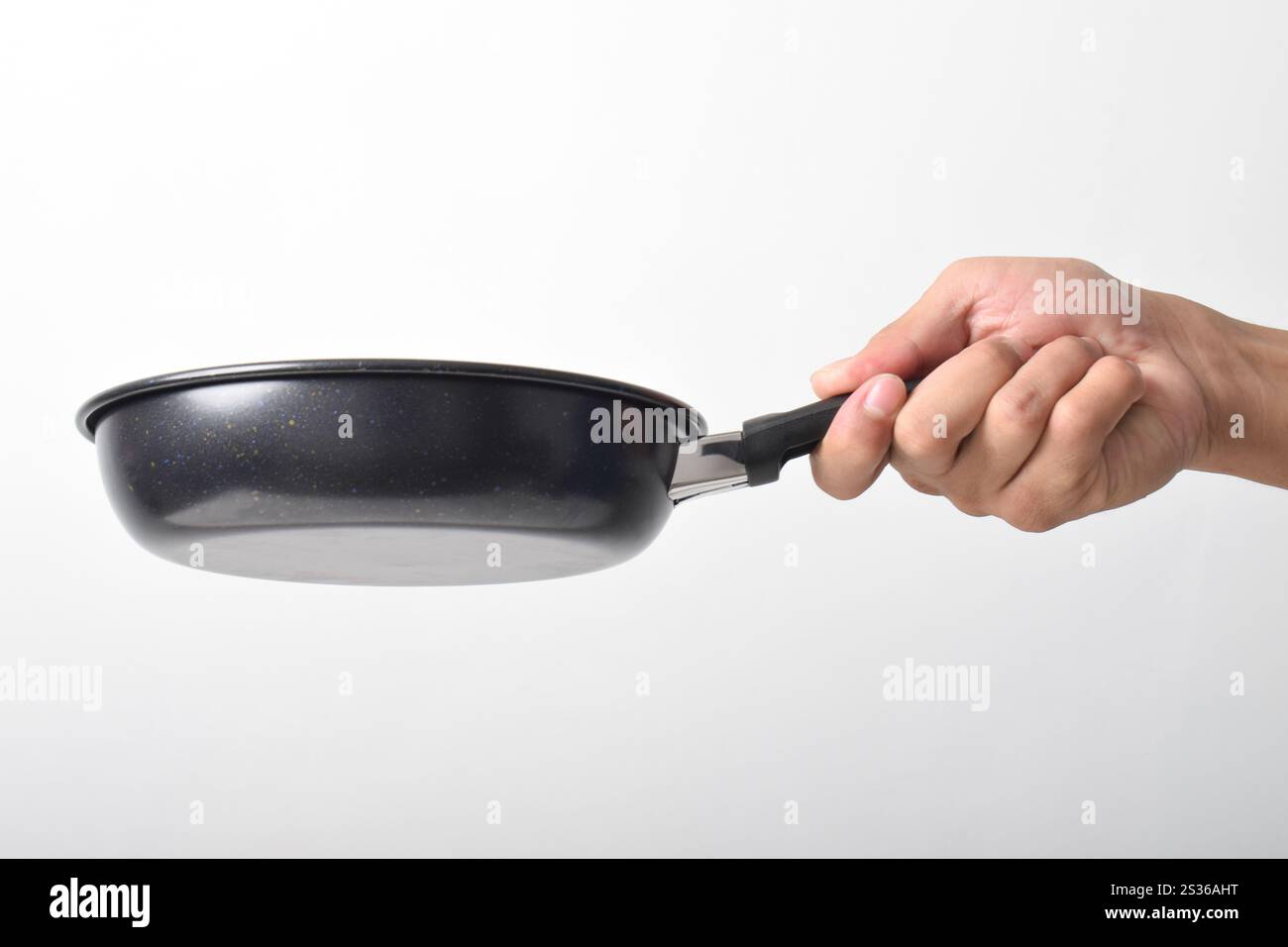 Hand holding Black frying pan with a non-stick coating isolated on ...