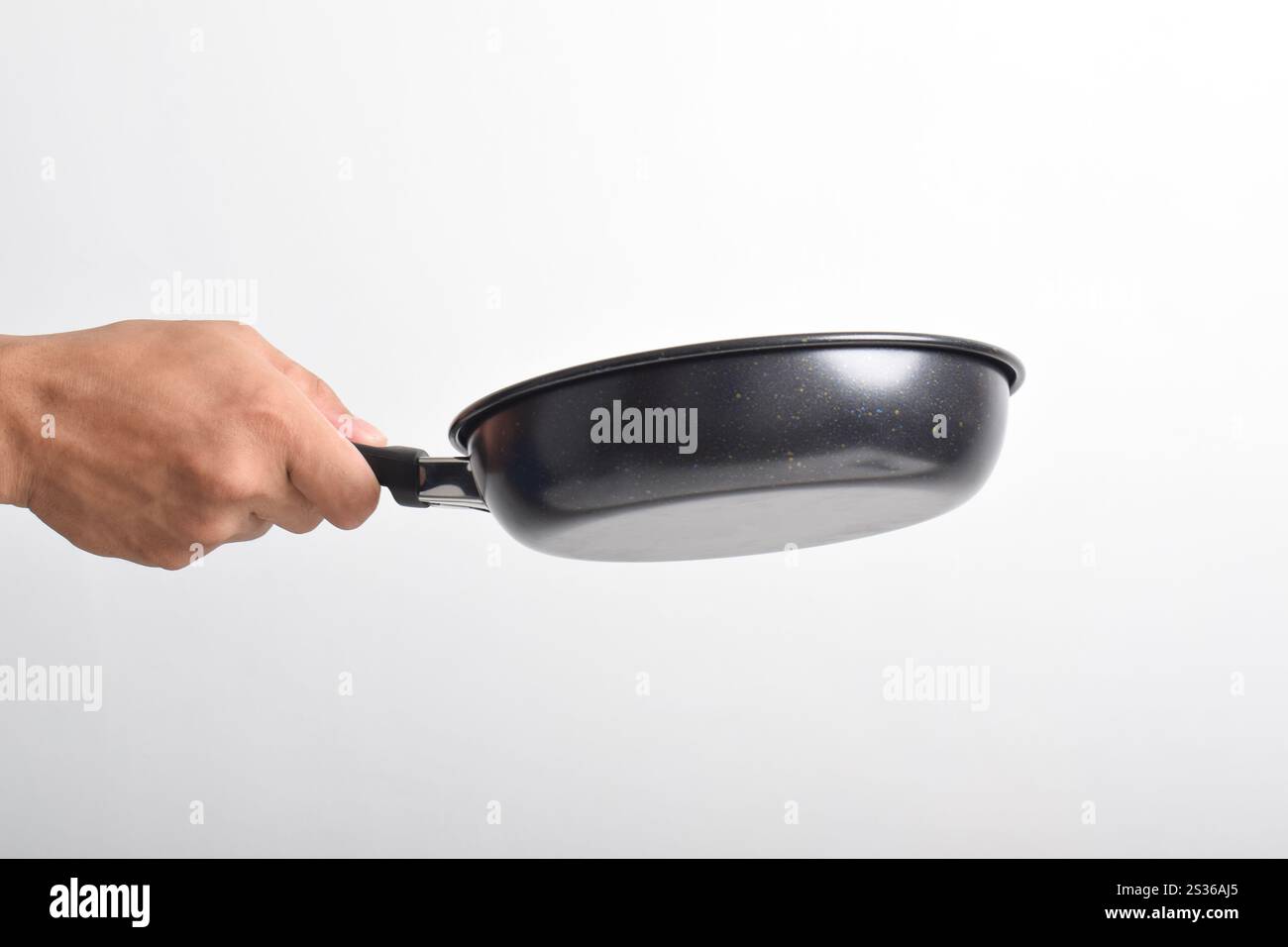 Hand holding Black frying pan with a non-stick coating isolated on ...