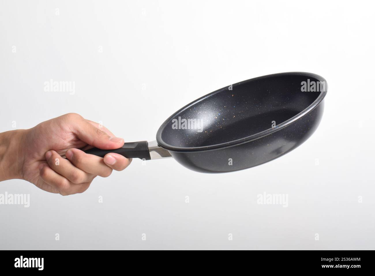 Hand holding Black frying pan with a non-stick coating isolated on ...