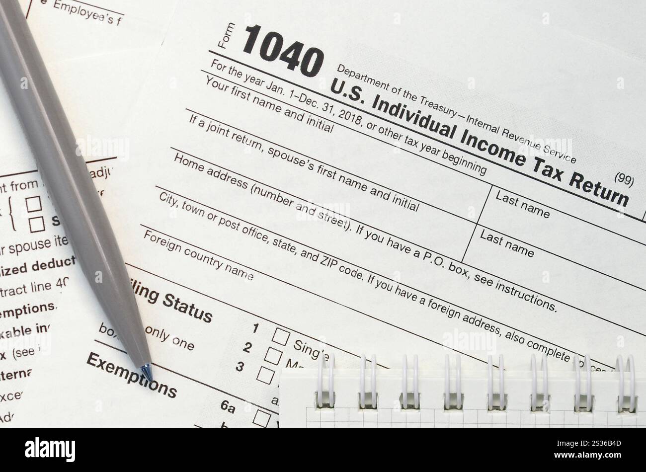 The pen and notebook is lies on the tax form 1040 U.S. Individual ...