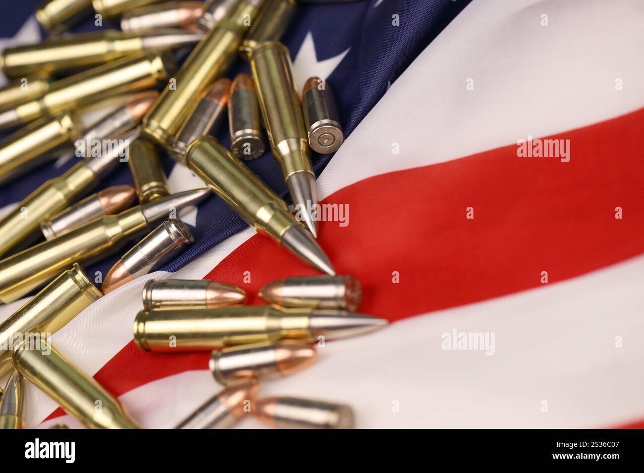 Many yellow 9mm and 5.56mm bullets and cartridges on United States flag ...