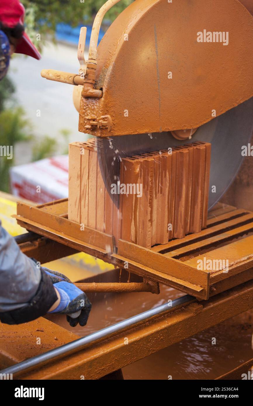 Construction worker cuts bricks for the construction of a detached ...