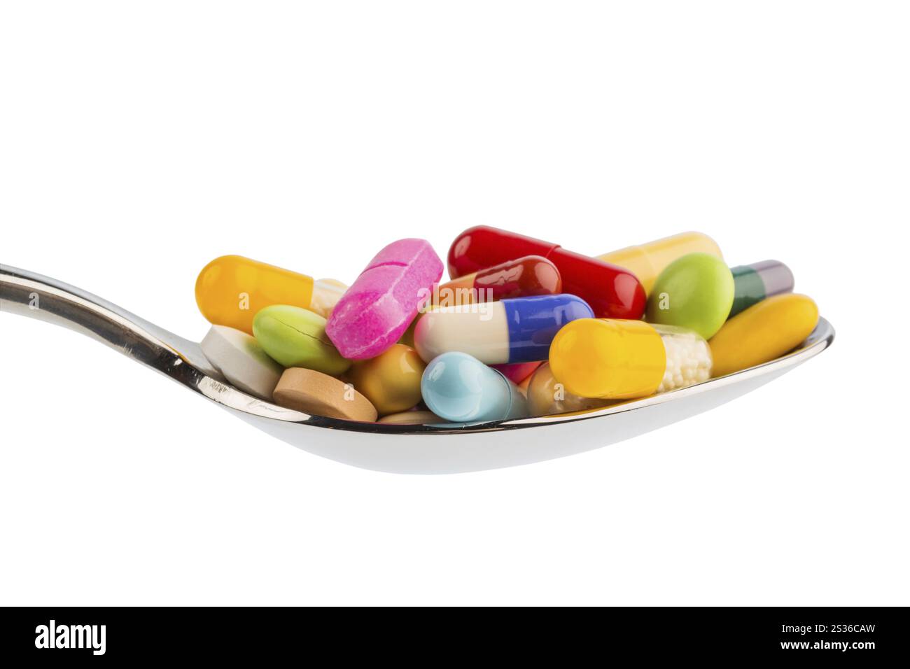 Many colourful tablets on a spoon. Symbolic photo for tablet addiction ...