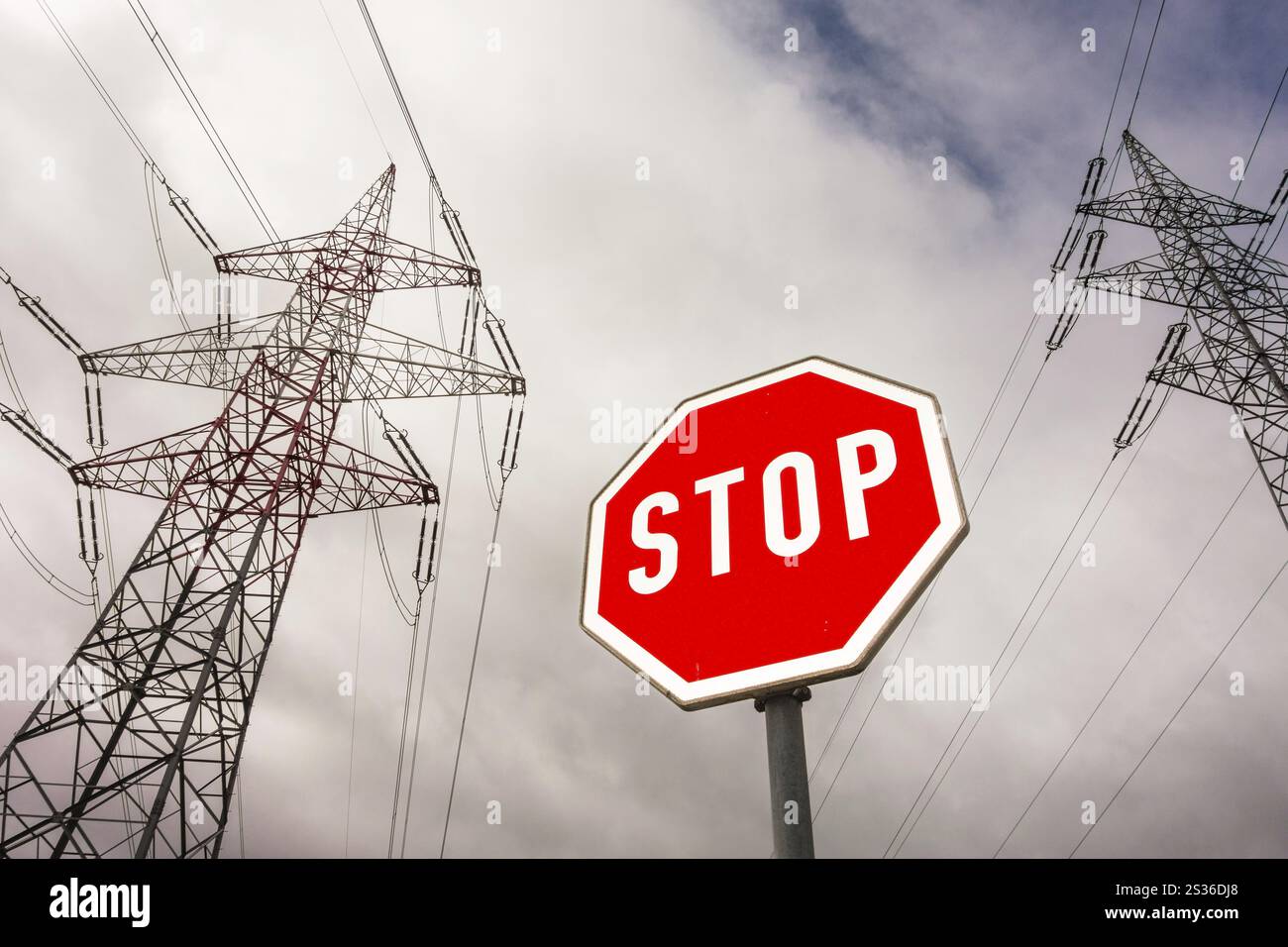 A pylon of a power line and a stop sign. Symbolic photo for phasing out ...