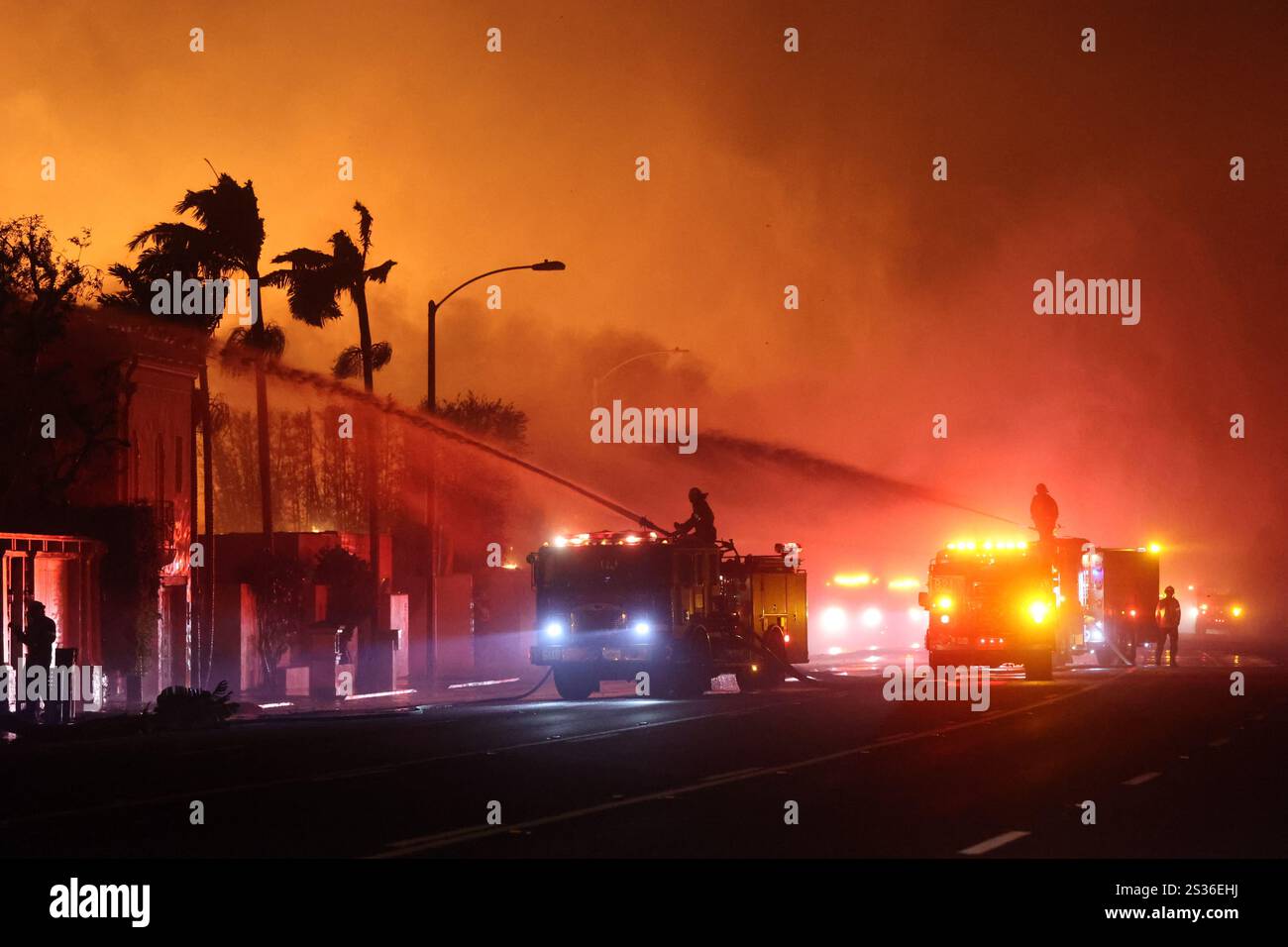 Firefighters spray water on burning structures to contain the rapid ...