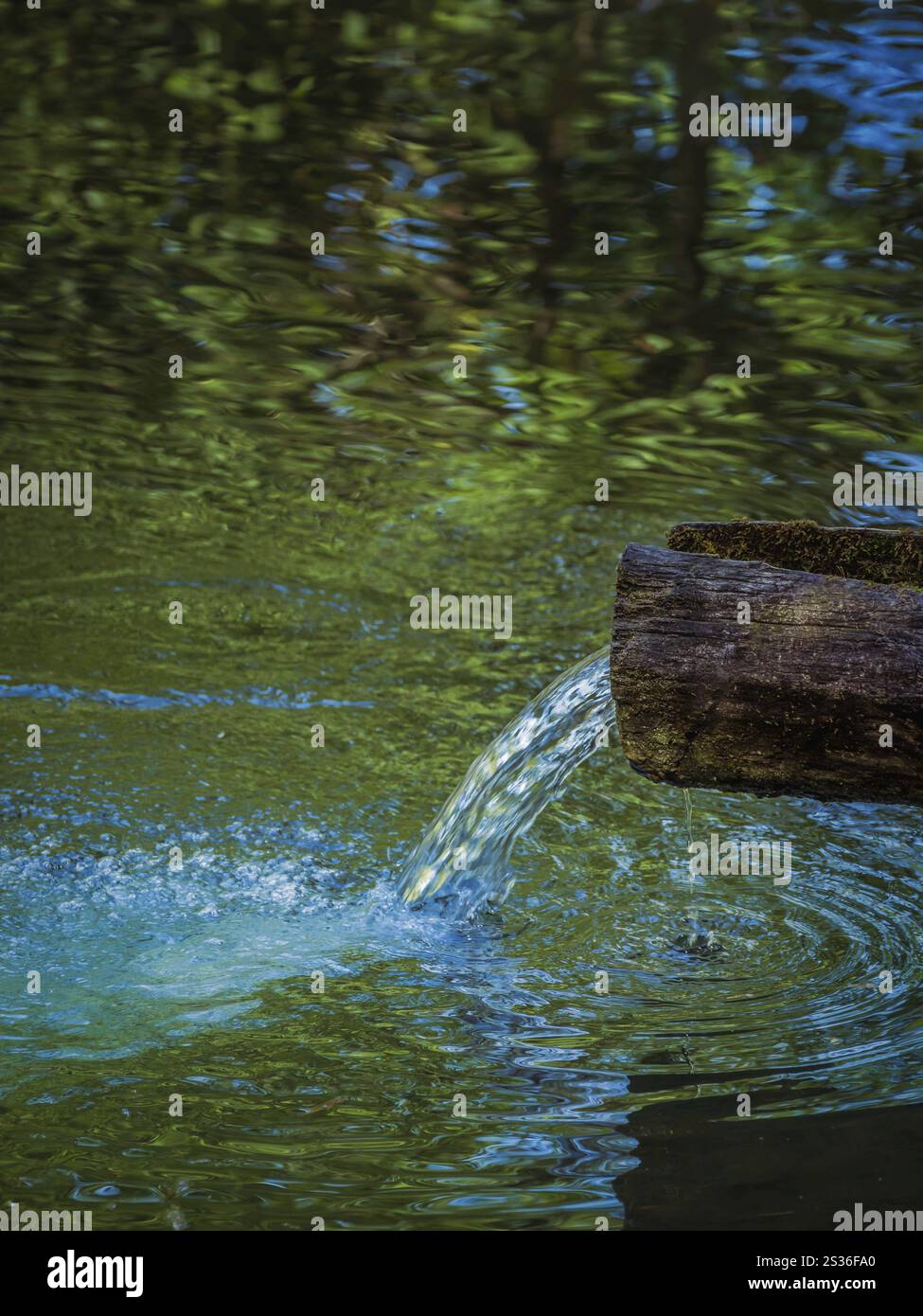 Drinking water from a spring flows into a lake. Symbol for pure water ...