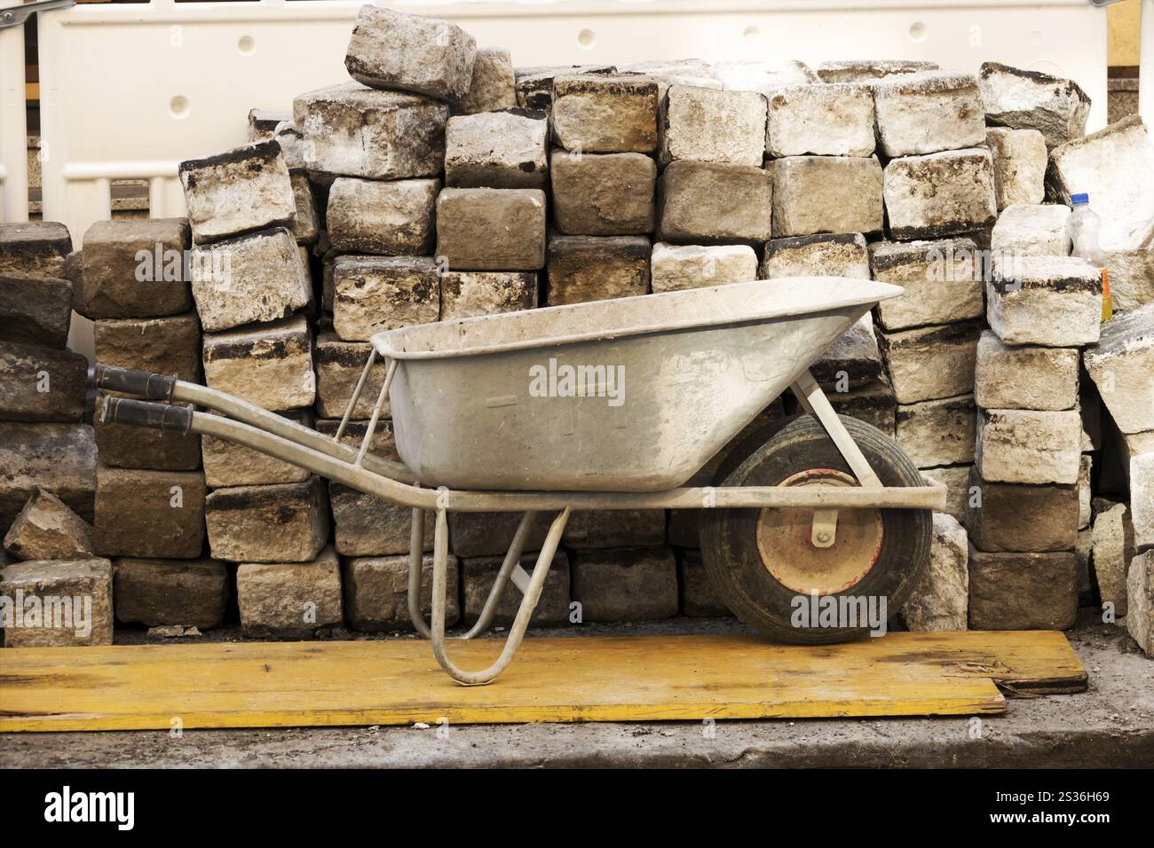 Wheelbarrow and large stones, symbol for construction industry ...