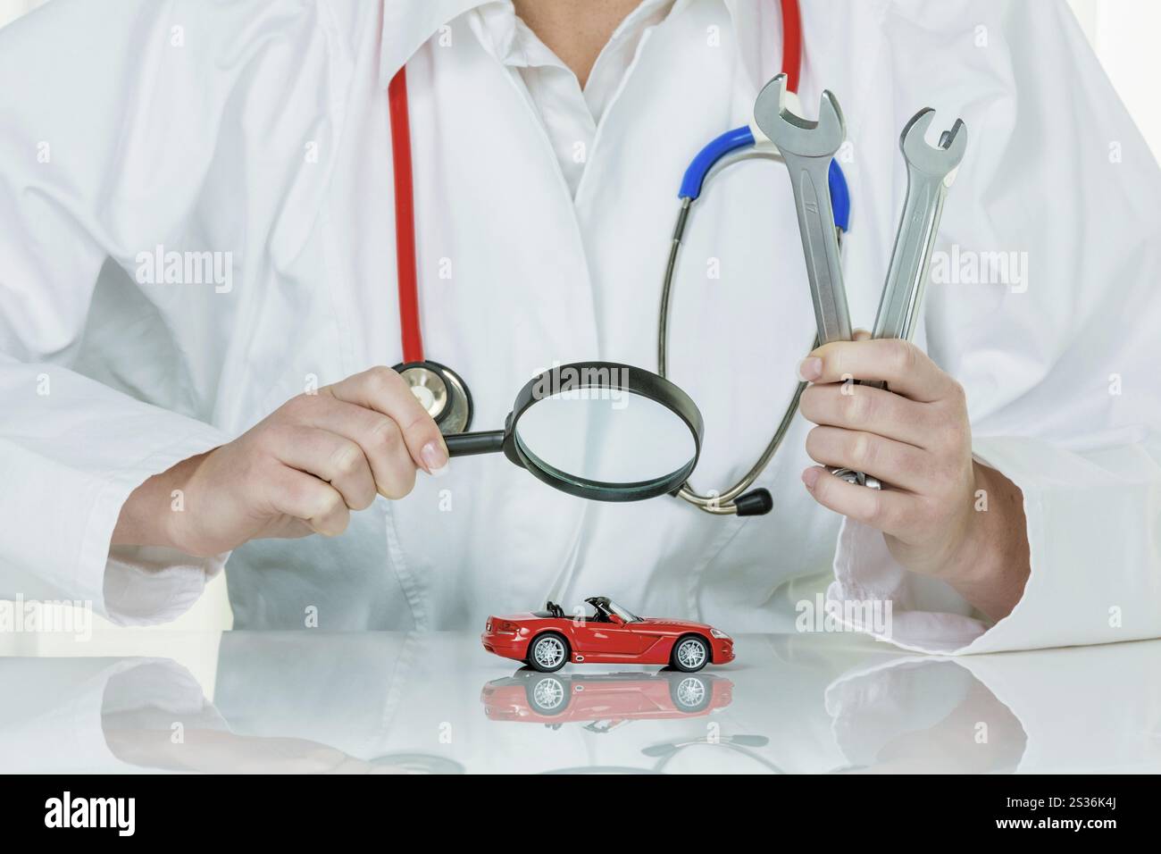 A model of a car is examined by a doctor. Symbol photo for workshop ...