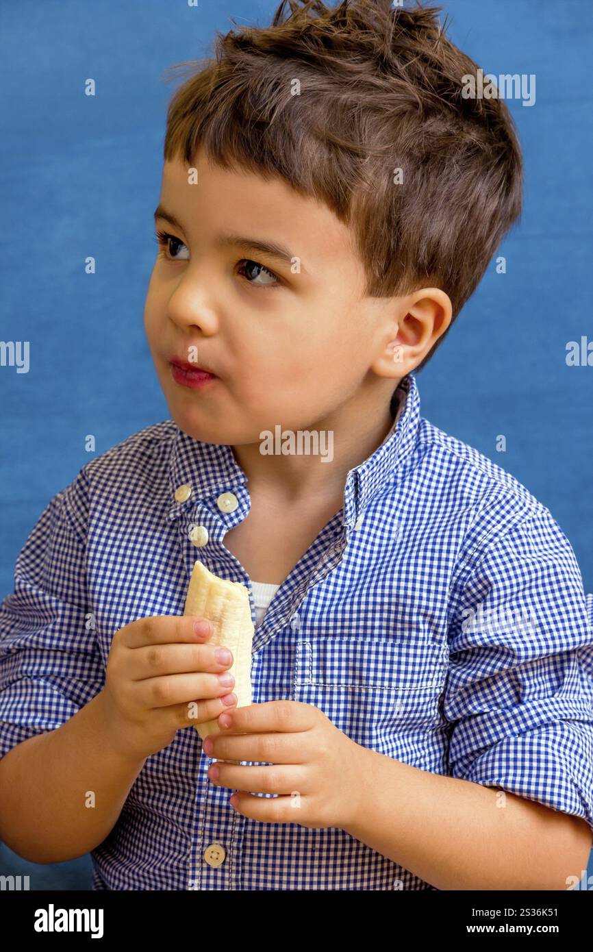 A little boy eats a banana. Symbolic photo for Ernaehrung Austria Stock ...