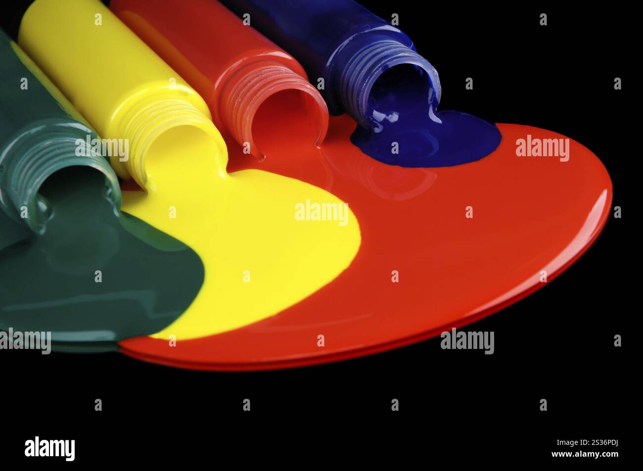 Different colors of paint flowing from tubes spilled on black ...