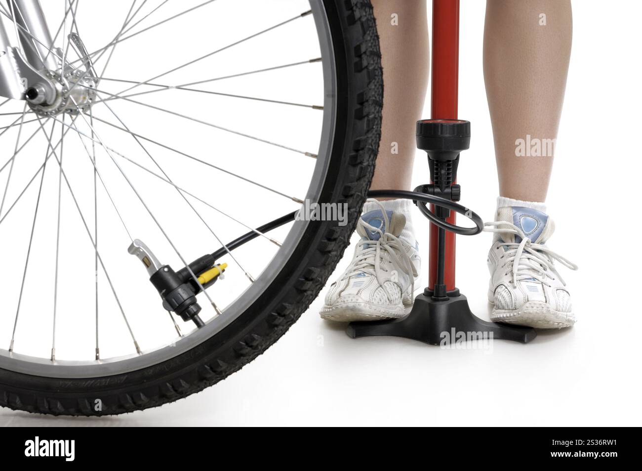 Young woman inflating bicycle tire with a pump Closeup of legs Isolated ...