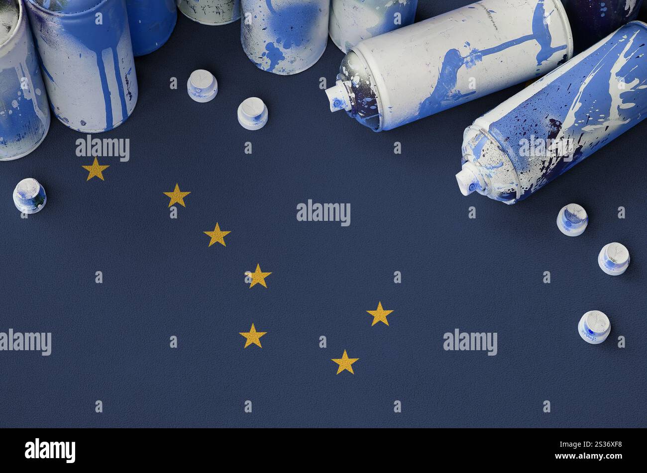 Alaska US state flag and few used aerosol spray cans for graffiti ...
