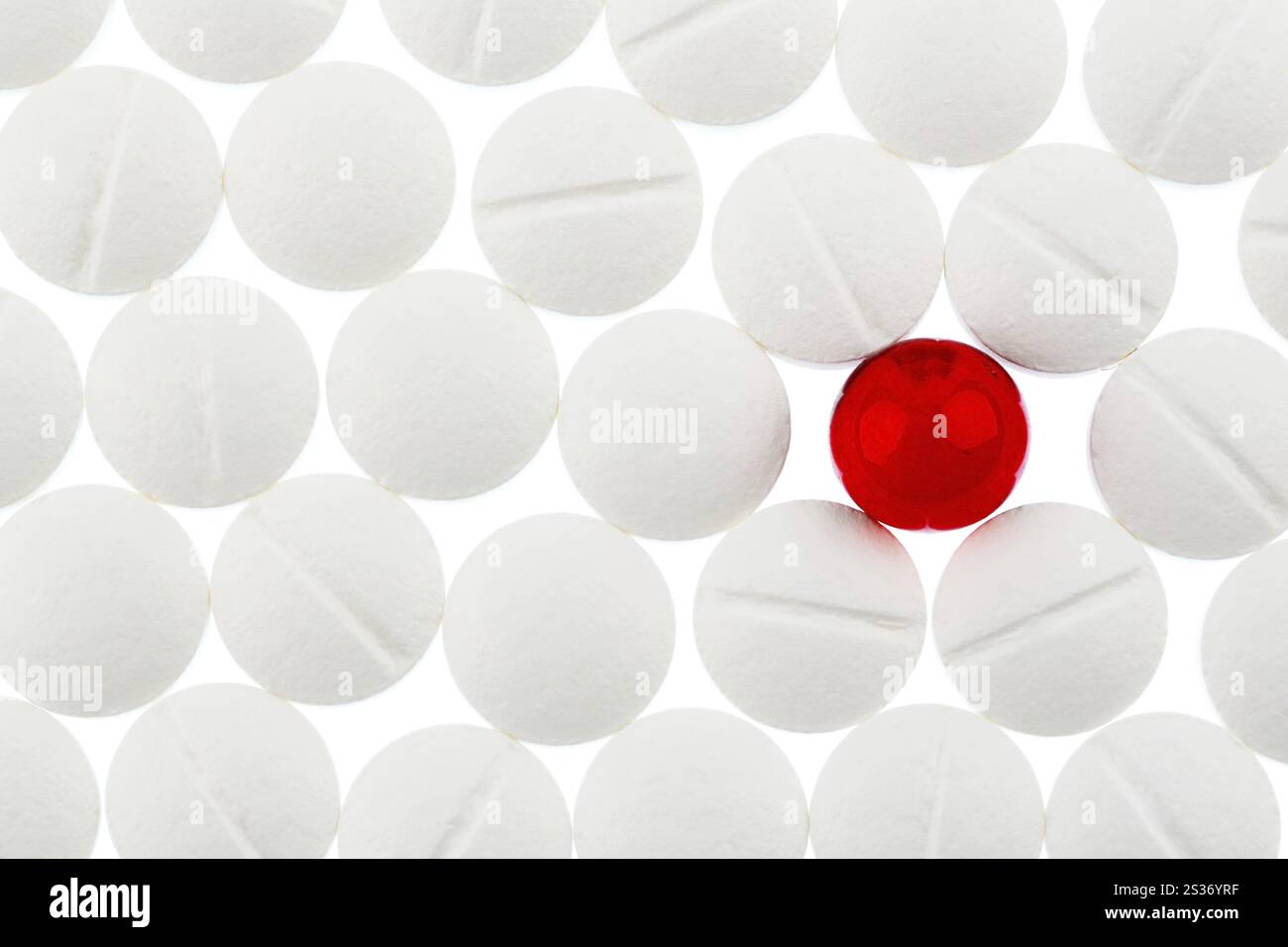 White tablets in contrast with a red tablet, symbolic photo for ...