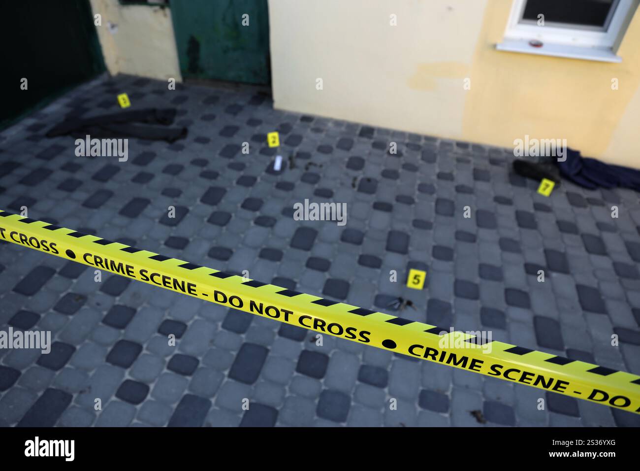 Crime scene tape for covering the area cordon. Yellow tape with blurred forensic law enforcement ...