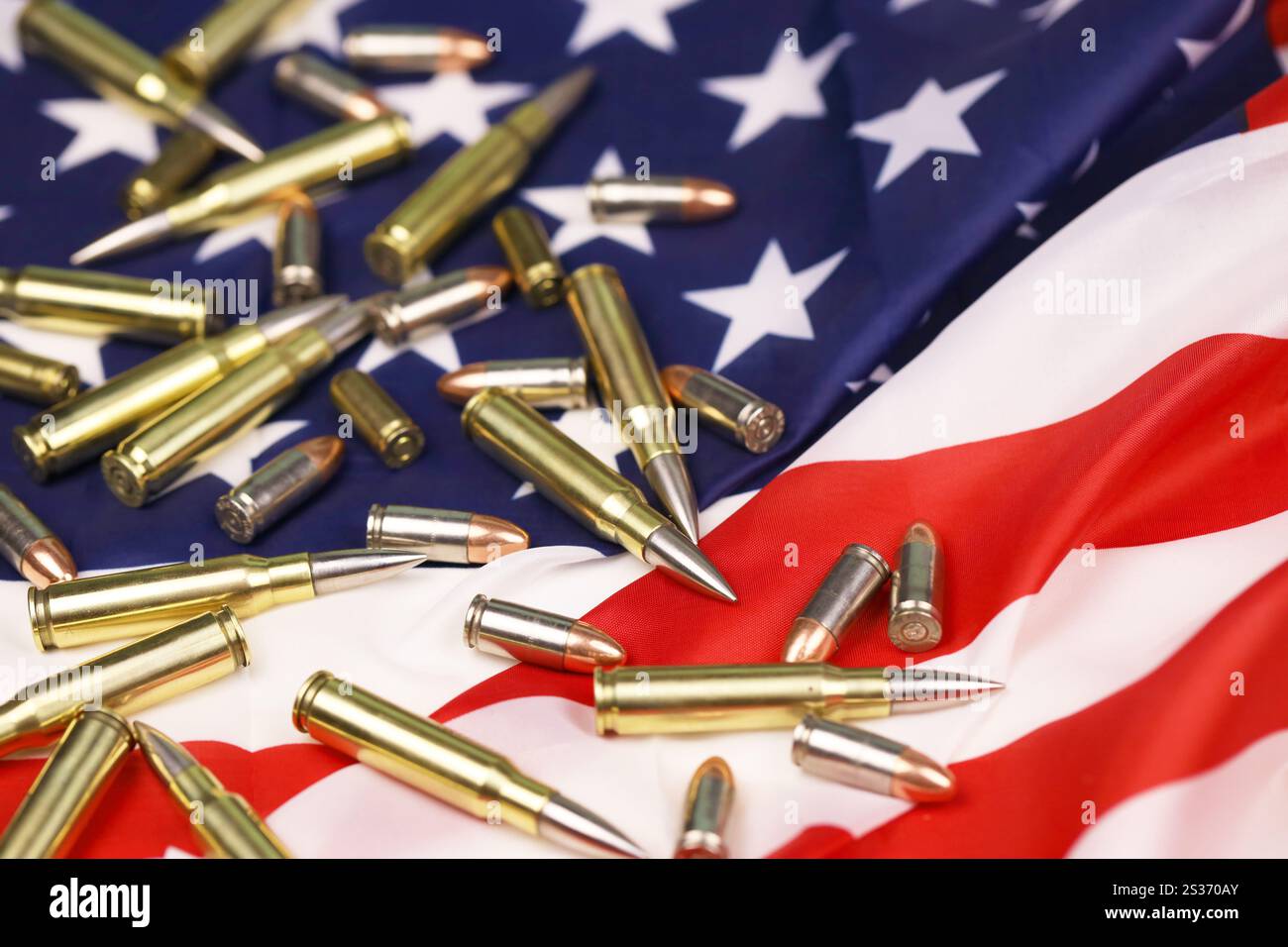 Many yellow 9mm and 5.56mm bullets and cartridges on United States flag ...