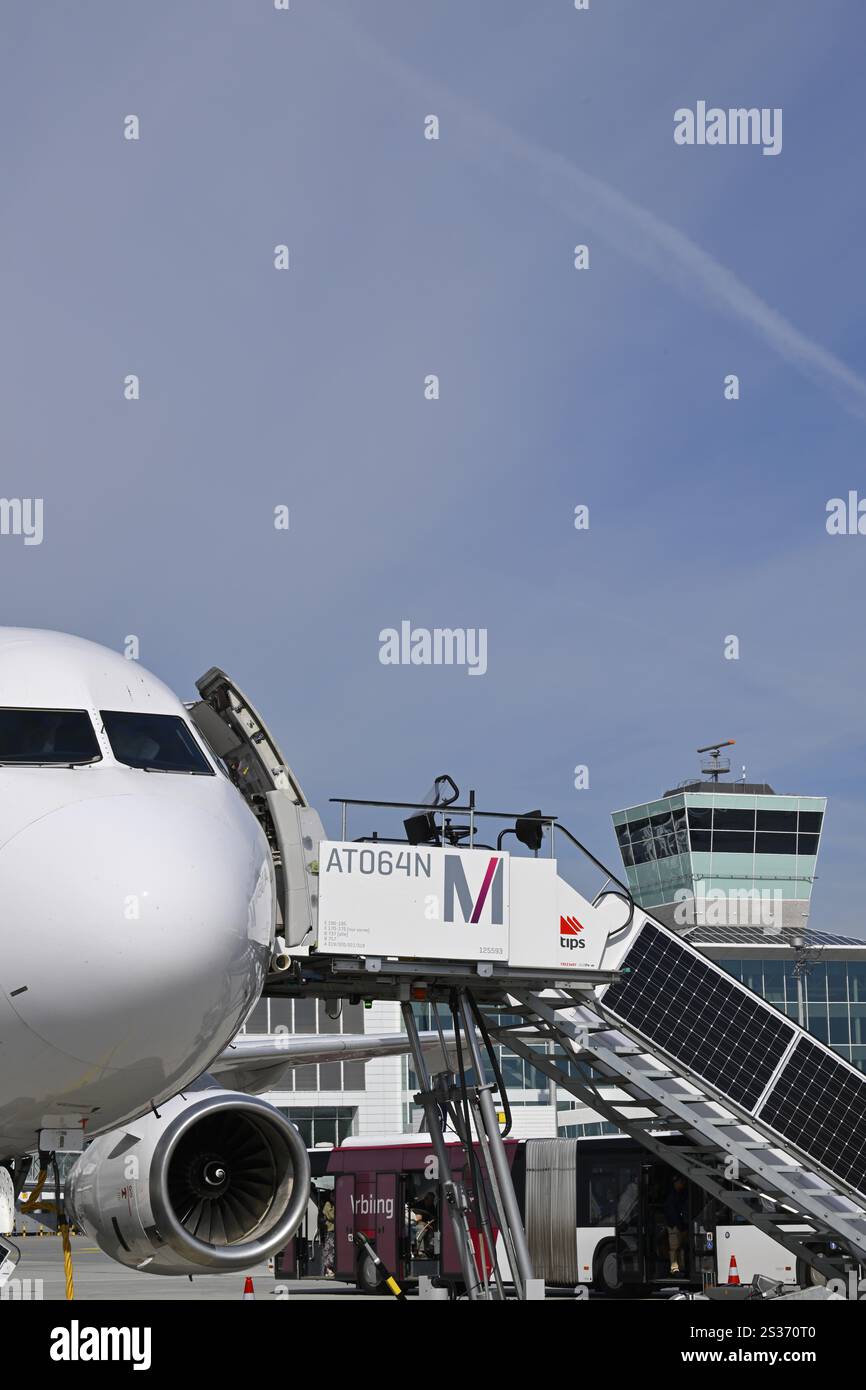 Airbus aircraft at check-in position with solar passenger stairs, bus ...