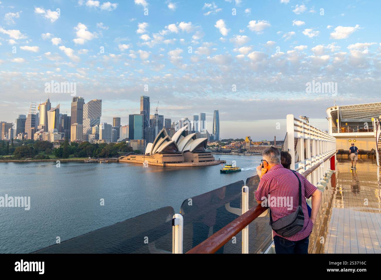 Cruise ship passengers look towards Sydney Opera House and Sydney city ...