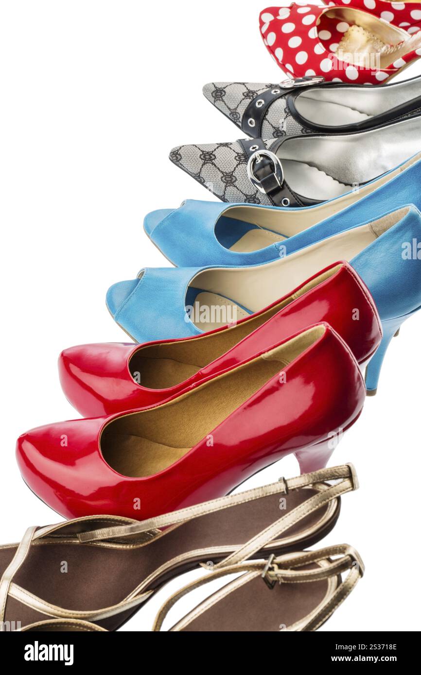 Different coloured shoes with high heels in front of a white background ...