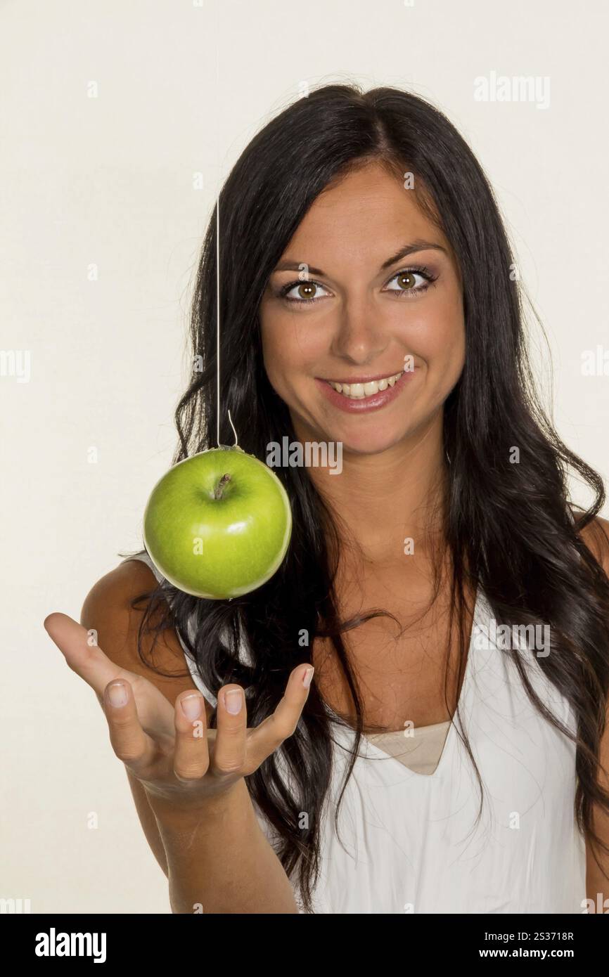 A young woman holds an apple in her hand. Fruit and vegetables for a healthy and vitamin-rich ...