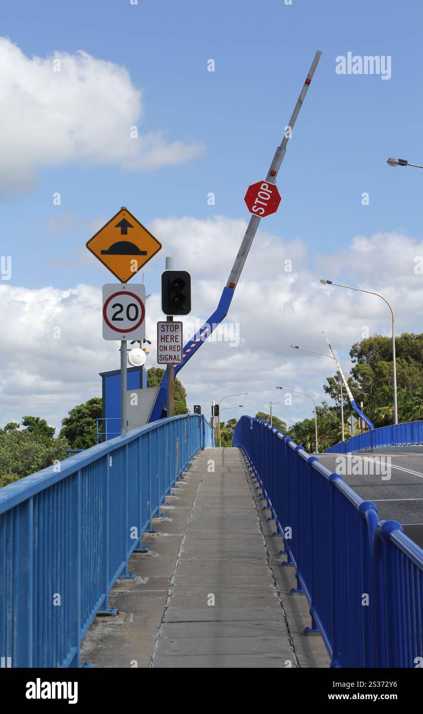 Walkway with signs, traffic light and boom gate over the Gladstone ...