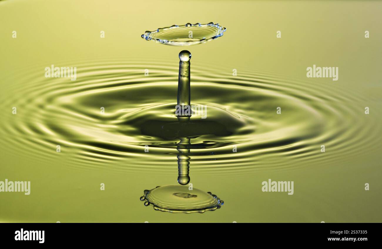 Gravity Dancing drop of water on a green background Stock Photo - Alamy