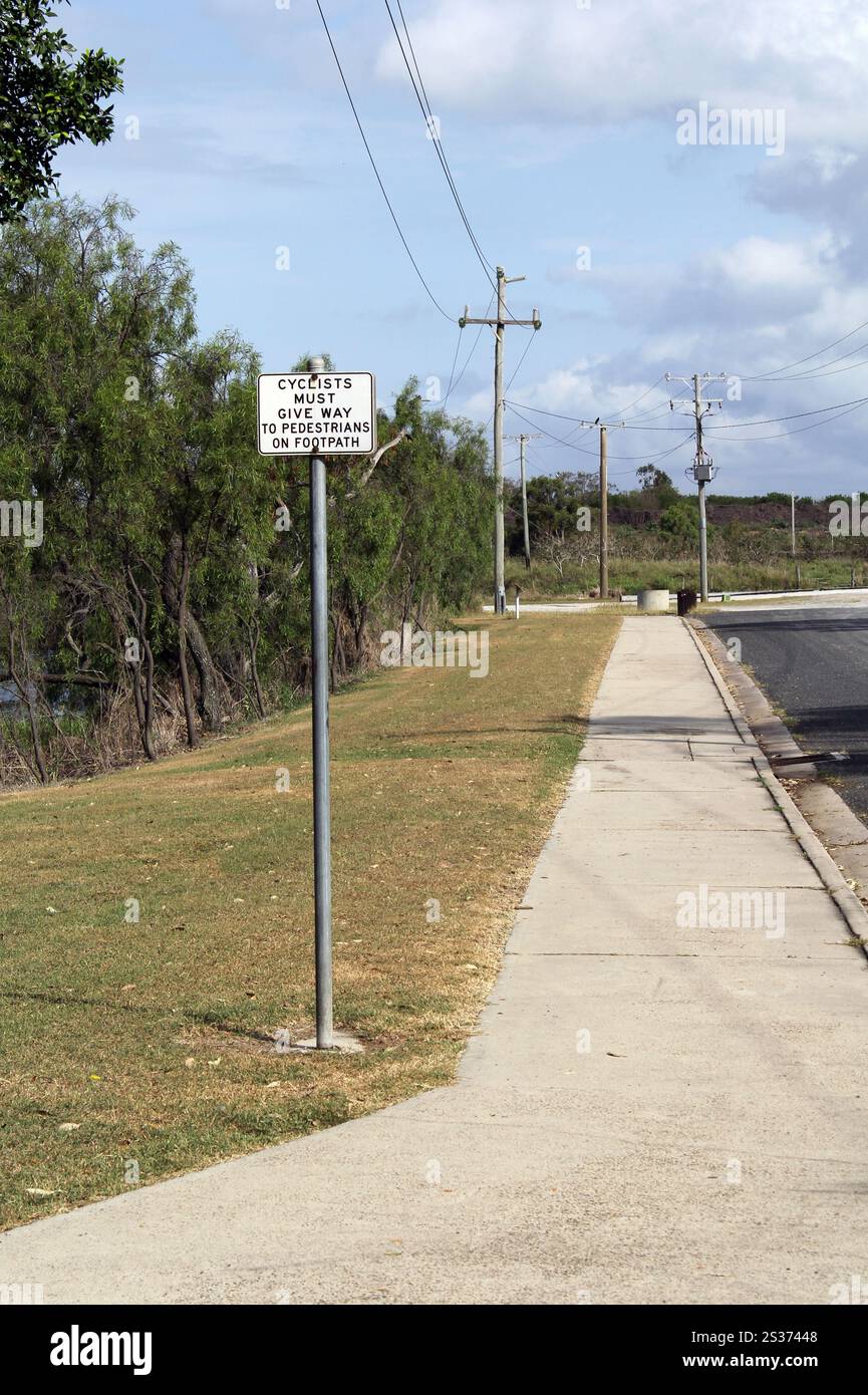 "Cyclists must give way" road sign next to a pedestrian footpath with ...