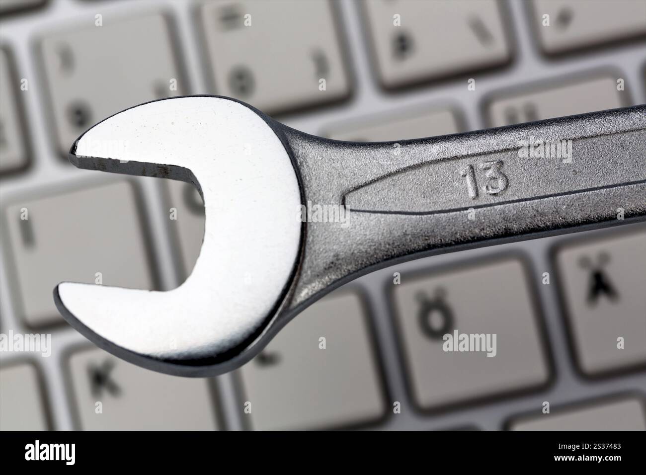 A spanner as a tool on a computer keyboard. Symbolic photo for data ...