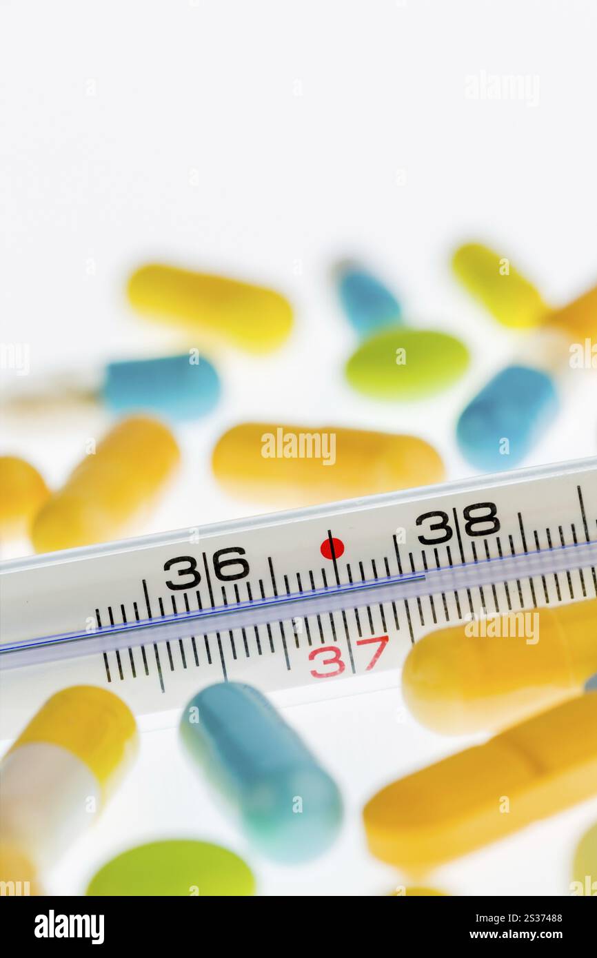 A clinical thermometer and tablets. Symbol photo for flu and colds ...