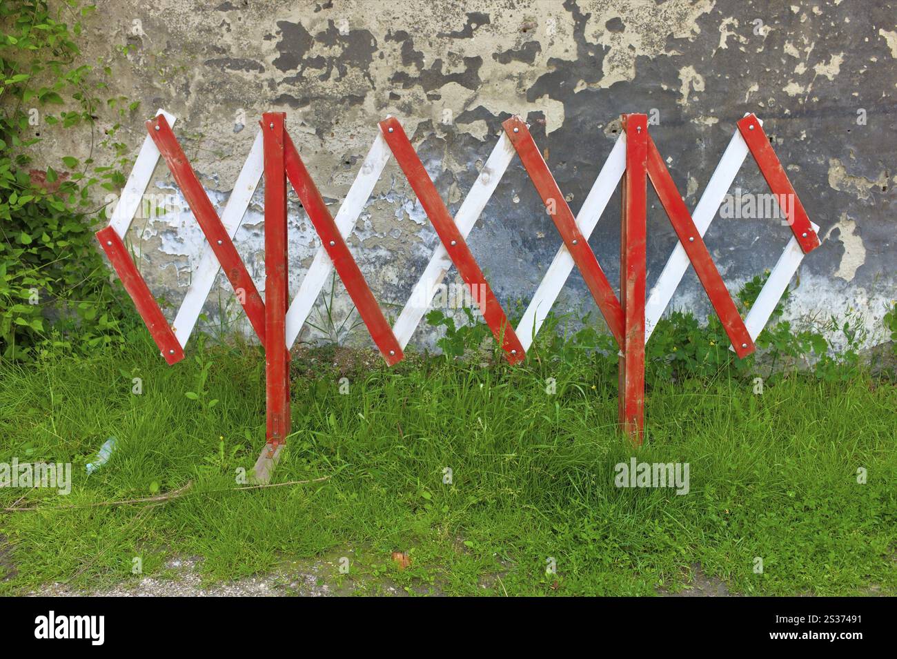 Barrier fence in front of concrete wall Stock Photo - Alamy