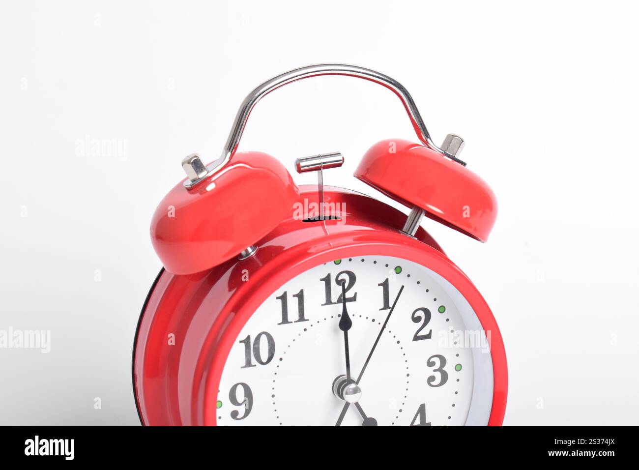 Red alarm clock set at five o'clock isolated on white background. Close ...