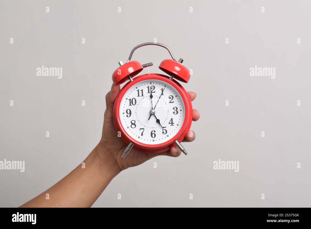 Vintage red alarm clock in hand. Round red alarm clock isolated on ...