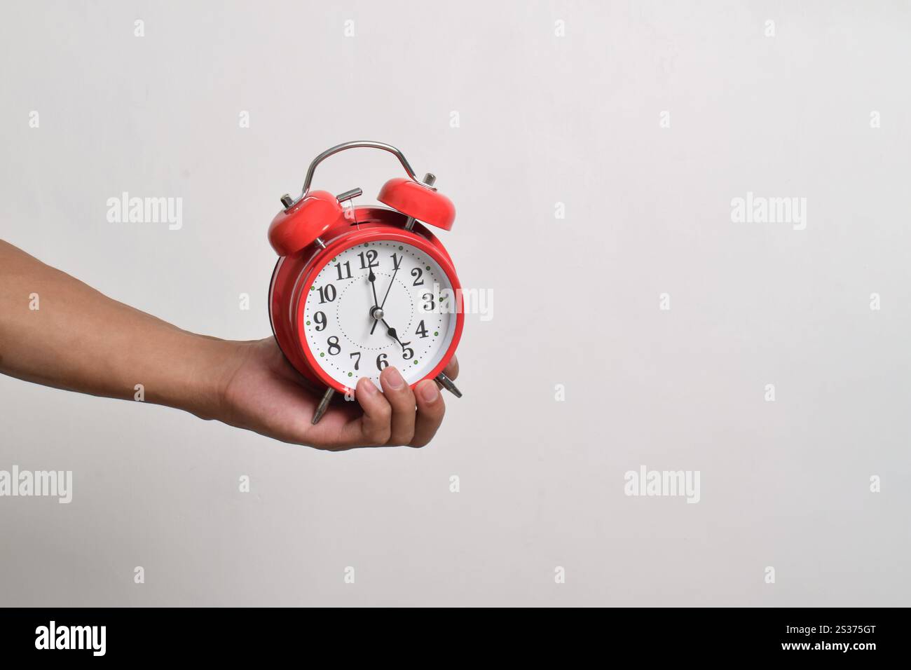 Vintage red alarm clock in hand. Round red alarm clock isolated on ...