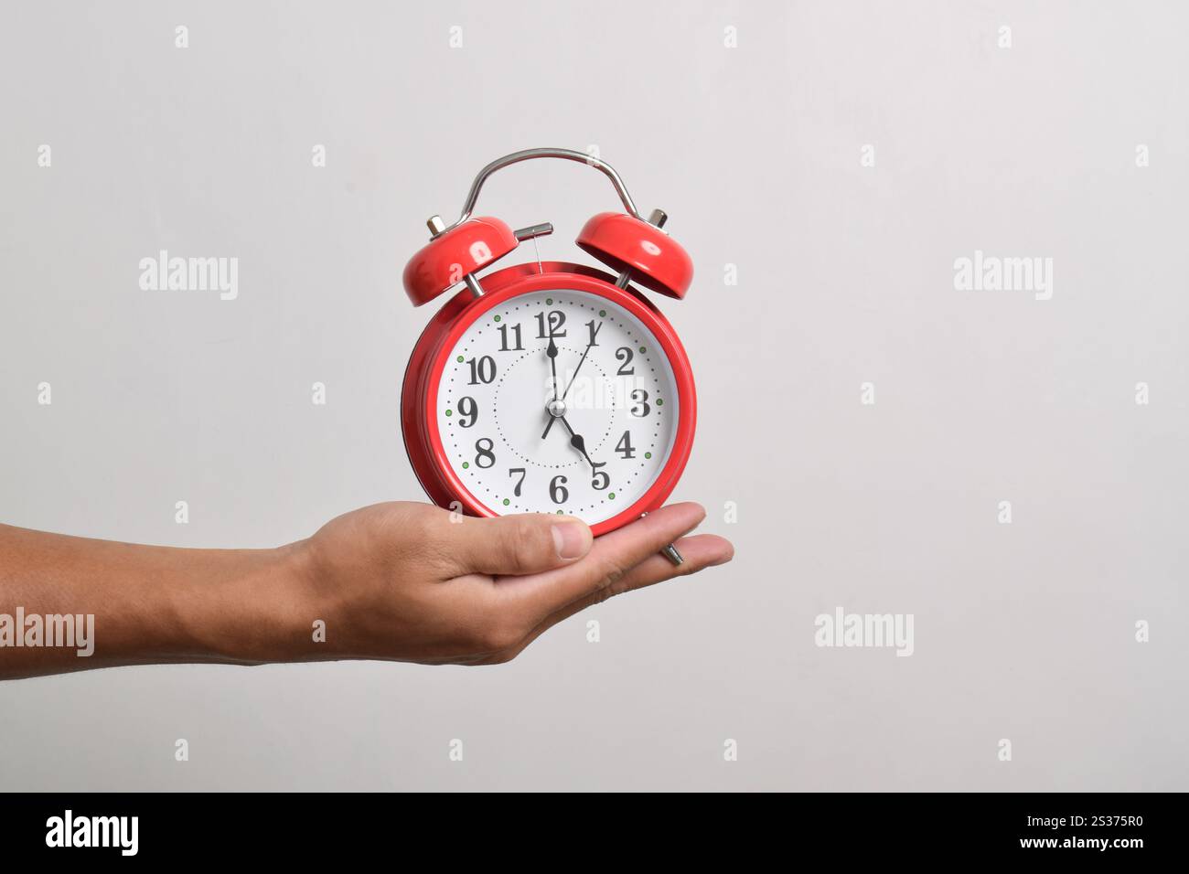 Vintage red alarm clock in hand. Round red alarm clock isolated on ...