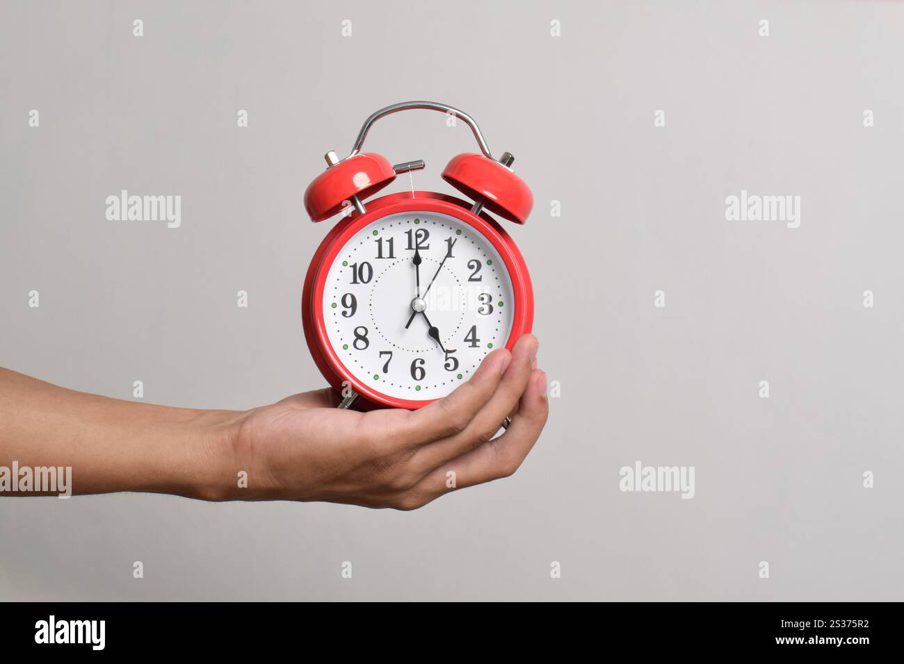 Vintage red alarm clock in hand. Round red alarm clock isolated on ... Vintage red alarm clock in hand. Round red alarm clock isolated on ...